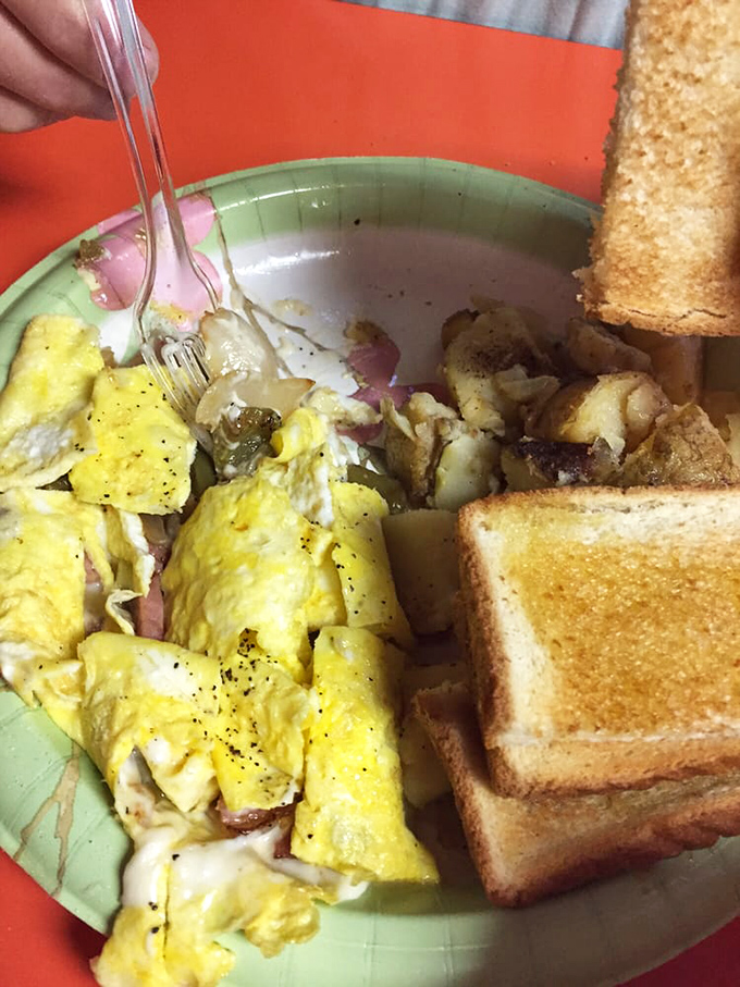 Scrambled eggs mingling with ham and potatoes on a colorful plate—breakfast democracy where every ingredient gets equal representation.