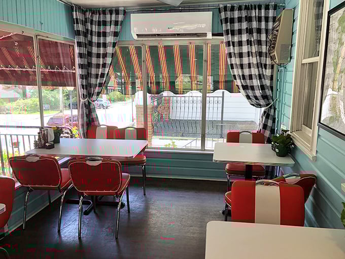 Black and white checkered curtains frame a dining space that feels like it belongs in a Norman Rockwell painting – nostalgia you can actually taste.