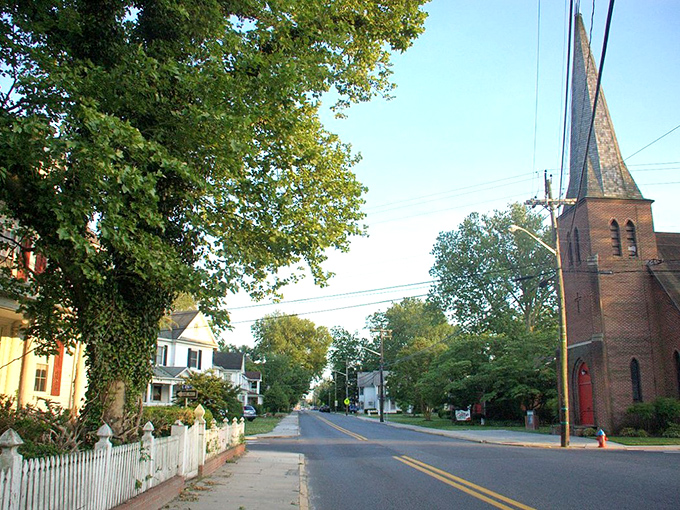 Laurel's tree-lined streets and historic church steeple create a postcard-perfect scene. The white picket fence completes this quintessential small-town vignette.