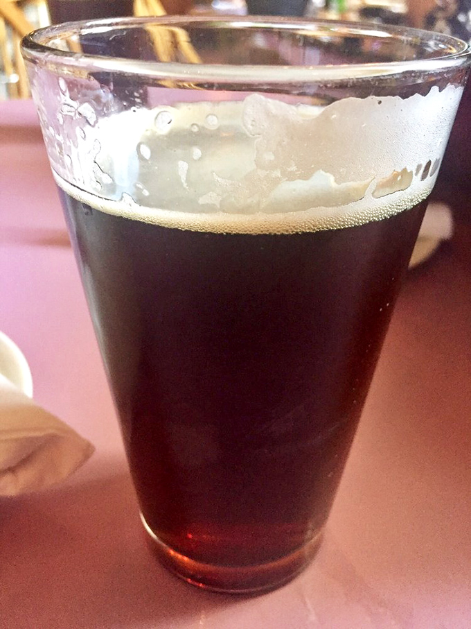 A perfectly poured dark ale with that photogenic foam cap—because sometimes the best dining companion doesn't talk back.