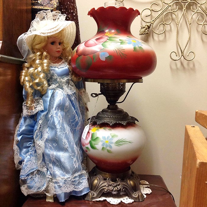 A vintage lamp with its hand-painted floral globe stands sentinel beside a porcelain doll—together they've witnessed decades of family conversations.