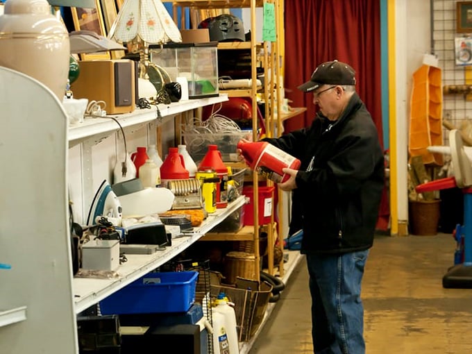 A shopper examines small appliances with the careful consideration of someone who knows that one person's abandoned bread maker is another's baking renaissance.