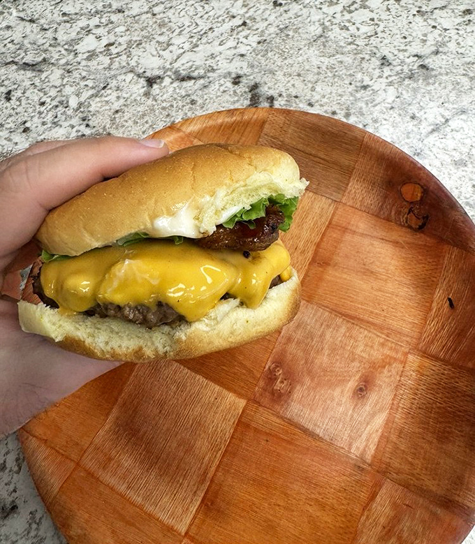 A cheeseburger caught in its natural habitat—simple, honest, and waiting to prove that sometimes the classics need no improvement.