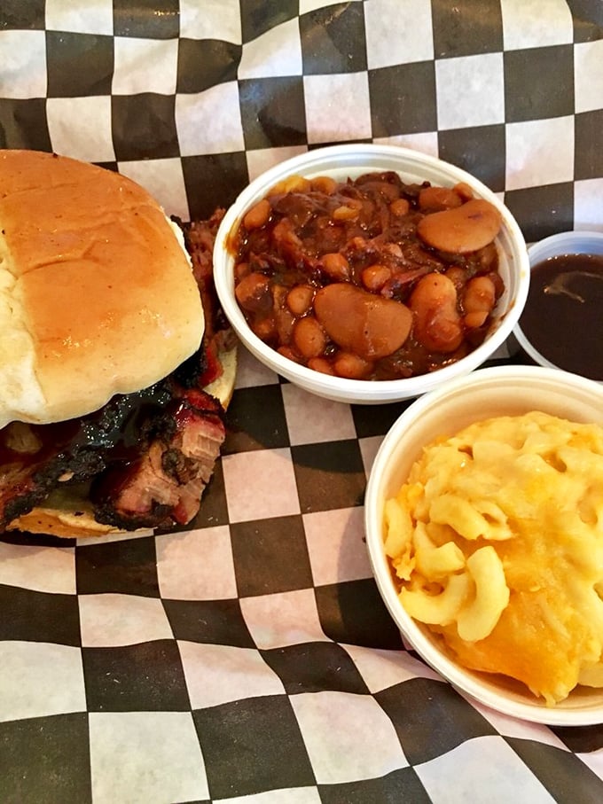 A barbecue sandwich flanked by mac and cheese and baked beans—the holy trinity of comfort that makes Monday feel like Saturday.