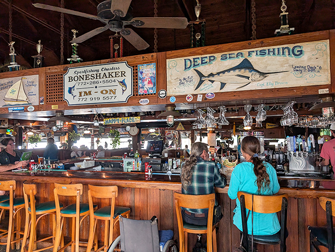 The bar area – where fishing trophies watch over patrons and bartenders craft liquid happiness with the efficiency of seasoned sailors.