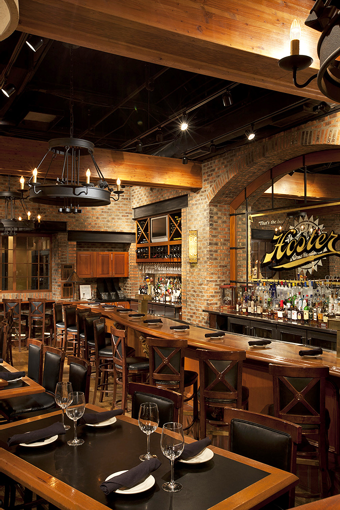 The bar area combines rustic charm with sophisticated service—where strangers become friends over perfectly poured drinks and shared appetizers.