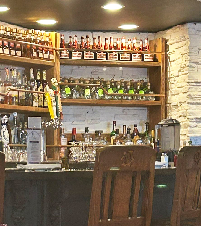 The bar showcases an impressive lineup of tequilas and spirits, standing at attention like soldiers ready to serve in your margarita of choice.