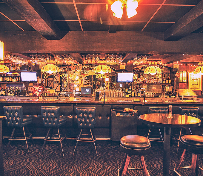 The bar area beckons with amber lighting and the promise of perfectly mixed classics – no mixology degree required to understand this menu.