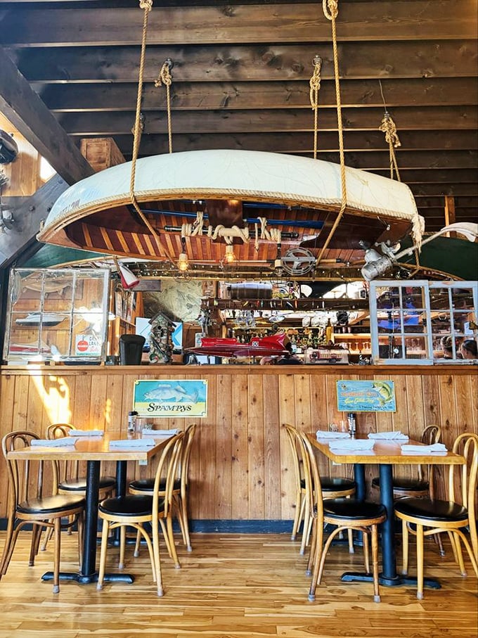 Vintage wooden boat hanging above diners—because nothing enhances appetite like the subtle reminder that you're eating beneath a suspended vessel.