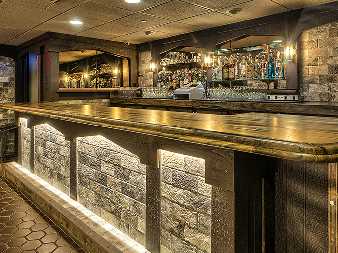 The bar isn't just where you wait for your table—it's a destination itself, with warm lighting and a stone facade that whispers "stay for one more."