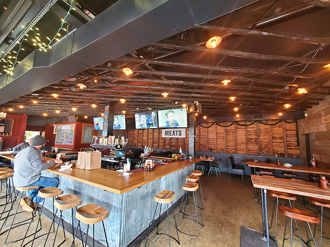 The bar area—where meat meets mingle. Industrial chic meets BBQ geek in this perfectly crafted corner of carnivore heaven.