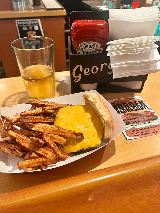 The holy trinity of tavern happiness: cold beer, hot burger, and hand-cut fries. Notice how the cheese drapes over the patty like a cozy yellow blanket.