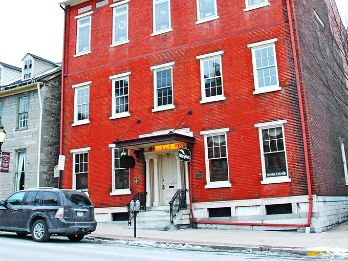This vibrant red building doesn't just house businesses—it anchors the street with the kind of architectural confidence they don't make anymore.