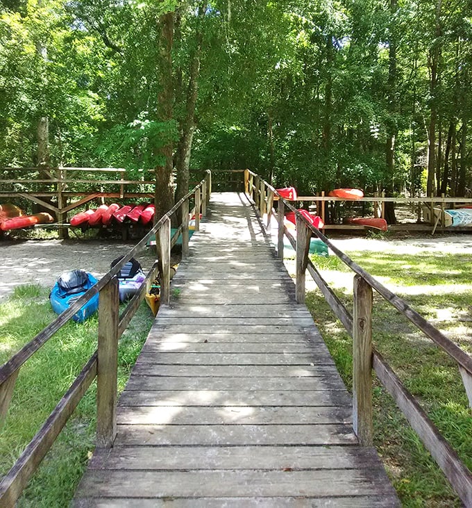 This wooden pathway leads to aquatic bliss. The red tubes aren't emergency equipment—they're your tickets to lazy river heaven.