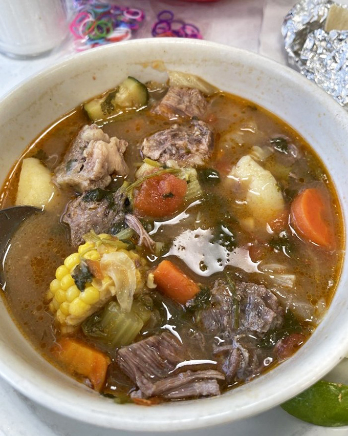 Caldo de res that simmers with intention – chunks of beef, corn, carrots, and potatoes in a broth so clear yet so complex it feels like liquid wisdom.