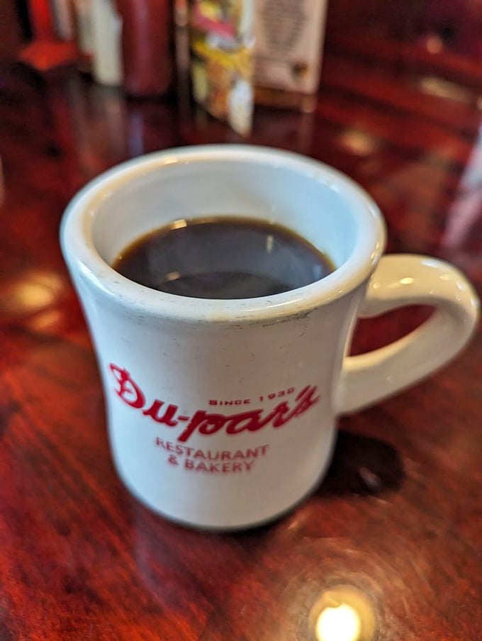That sturdy white mug isn't just holding coffee—it's cradling liquid motivation in a vessel that's witnessed countless morning revelations and late-night confessions.