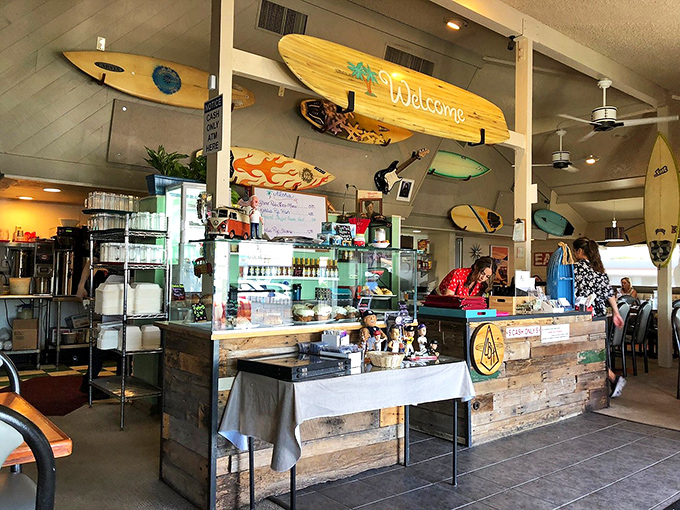 The heart of breakfast operations—where coffee flows freely and surfboards stand guard over morning rituals.