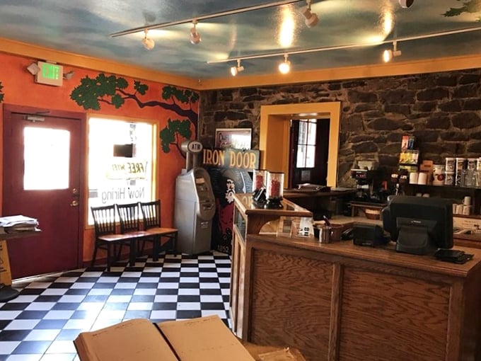 The entrance area's checkerboard floor and painted mural create a welcoming first impression that balances rustic charm with artistic flair.