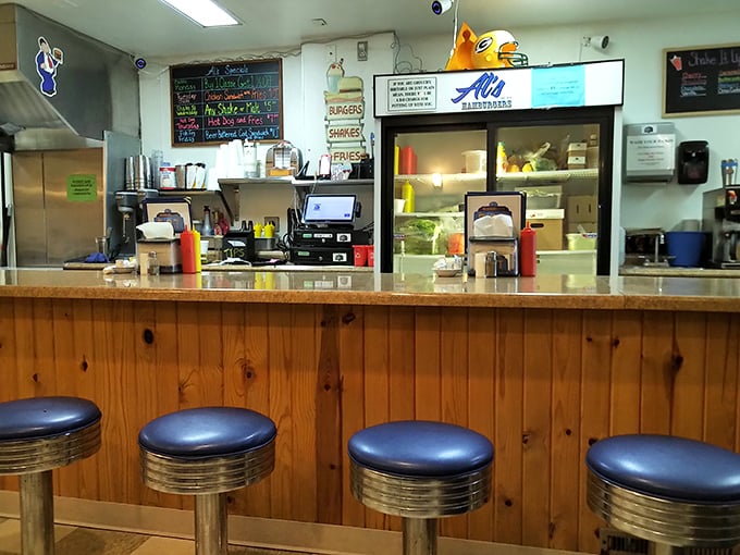 The counter at Al's—where regulars become family and first-timers become regulars. Those blue stools have supported generations of Green Bay residents seeking comfort food and conversation.