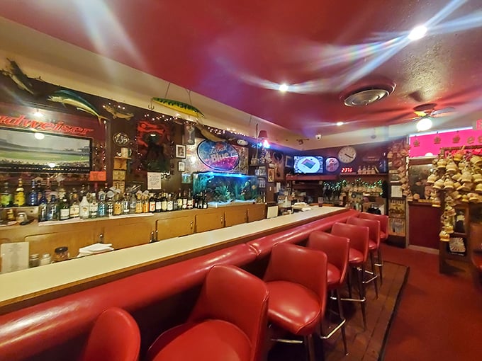 The bar at Loui's isn't trying to be trendy—it's been cool since before cool needed a definition. Those red stools have supported pizza lovers for decades.