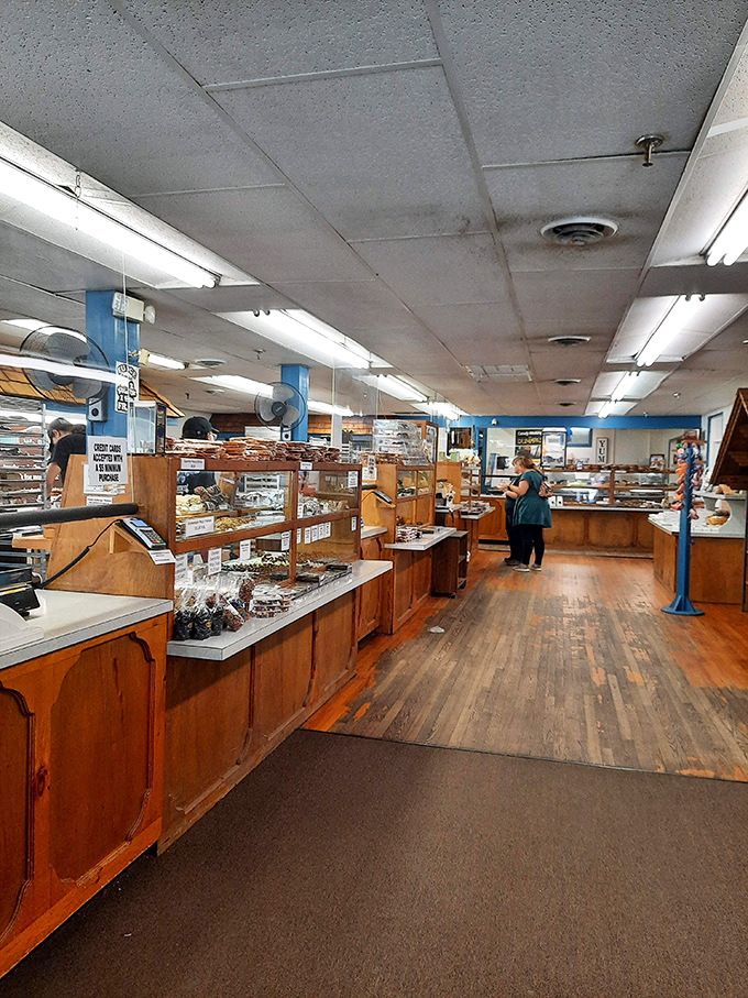 A candy wonderland stretching before you, with wooden display cases that have witnessed countless wide-eyed expressions of pure joy.