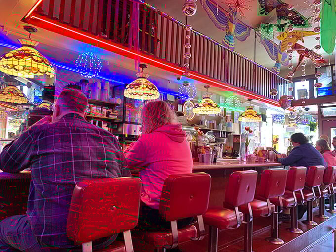 Counter culture at its finest—red swivel stools offer front-row seats to the breakfast show, where regulars and newcomers bond over shared appreciation for diner perfection.
