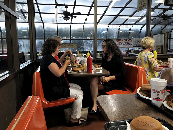 The sunlit dining area with its vintage orange booths feels like stepping into a time machine where calories don't count and conversations flow freely.