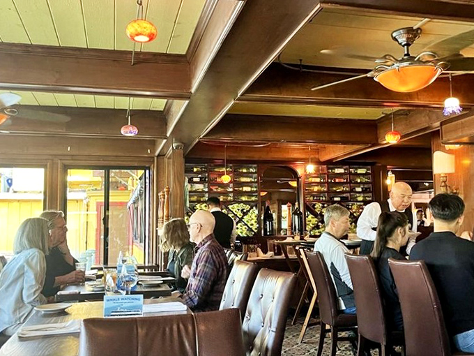 Diners bask in warm wood-paneled ambiance as attentive servers navigate between tables—the kind of place where conversations flow as smoothly as the wine.