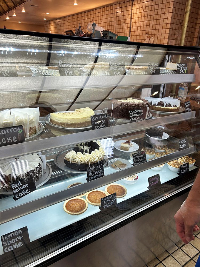 The dessert case – where willpower goes to die. Each handwritten label promises a different path to sweet satisfaction.