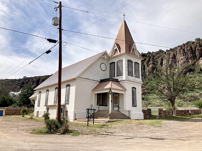 Pristine white against rugged terrain, this historic church has been gathering the faithful beneath its distinctive steeple for generations.