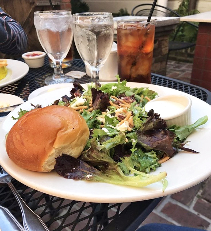 Simple pleasures shine: warm garlic rolls and fresh salad prove perfection lies in execution.