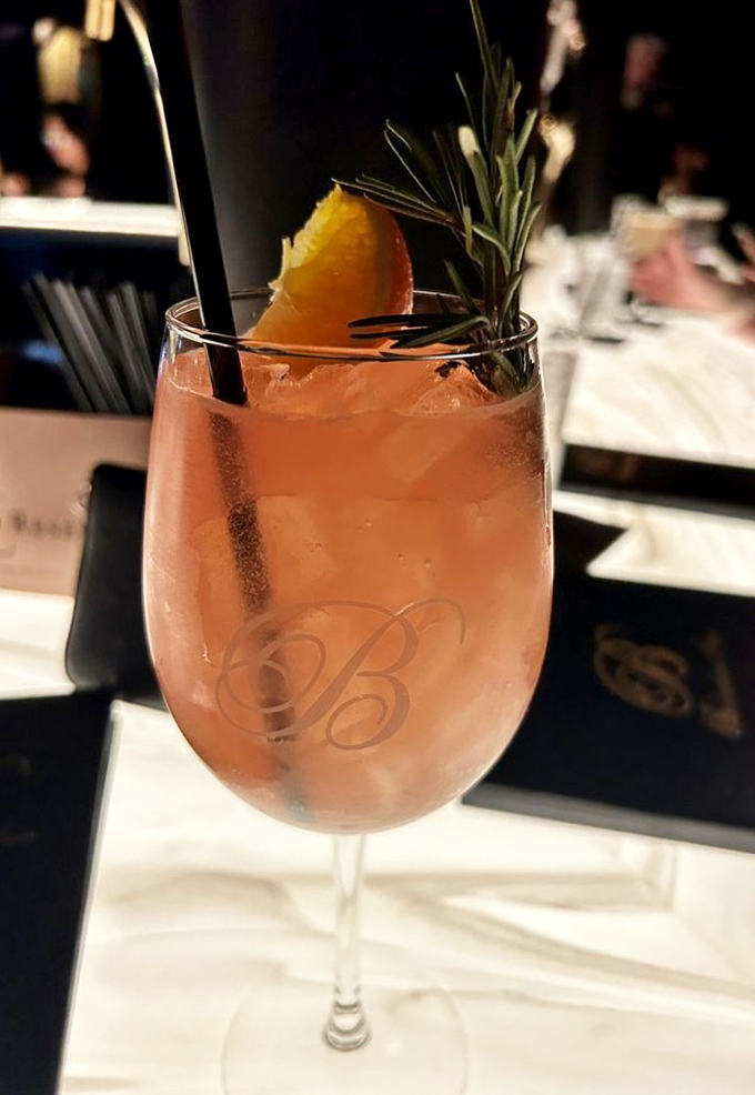 A cocktail that looks like a Pennsylvania sunset in a glass. That rosemary sprig isn't just garnish—it's aromatherapy.