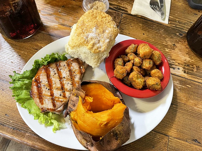 This isn't just lunch – it's a complete Ozark experience. Grilled pork chop, sweet potato, and those golden-fried okra nuggets that disappear too quickly.