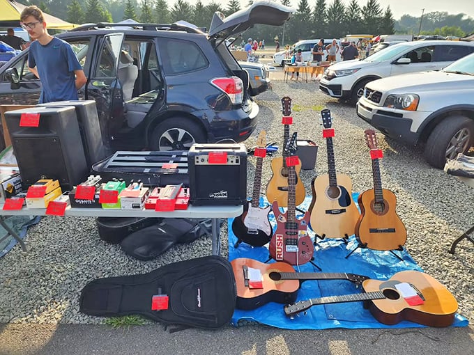 Six-string dreams laid out on blue tarps. From campfire sing-alongs to teenage rock star ambitions, these guitars await their next chord progression.
