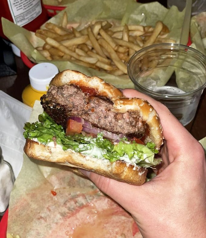 Cross-section evidence of burger perfection—juicy interior, proper meat-to-bun ratio, and cheese melted into every nook. This is burger science at work.