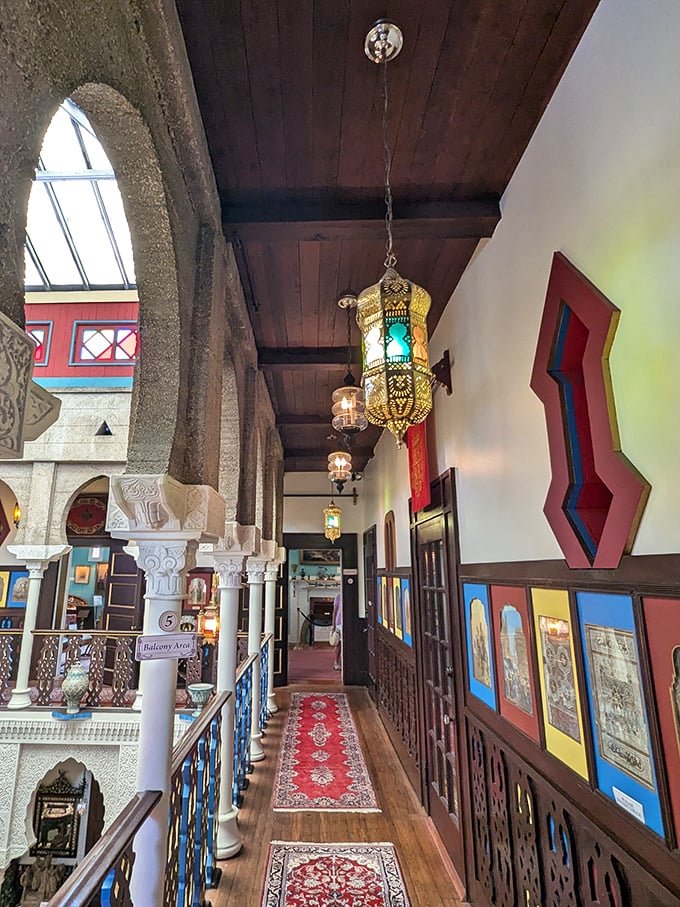 Moorish lanterns illuminate the upper gallery where Oriental rugs and carved railings transform a simple hallway into something from "One Thousand and One Nights."