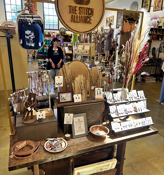 The Stitch Alliance display showcases handcrafted jewelry that makes mass-produced accessories look like they're not even trying. Wearable art with soul.