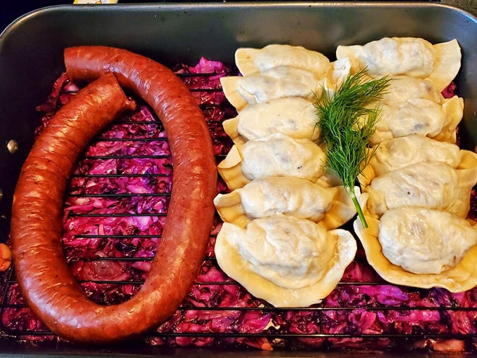 A perfect Polish-American marriage: kielbasa and pierogies sharing a pan with red cabbage, like the world's most delicious family reunion.