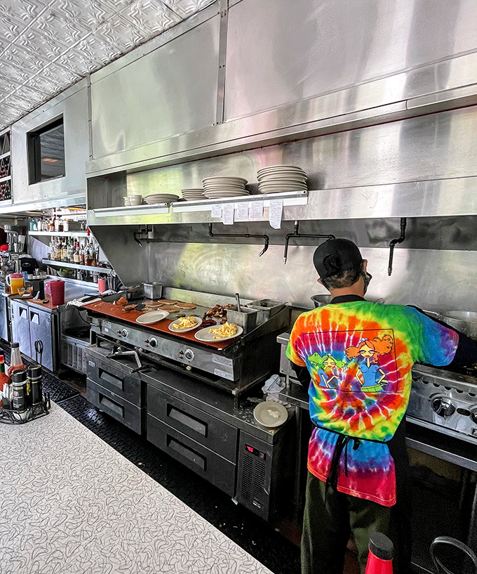 Behind the scenes magic—a tie-dye clad chef orchestrates breakfast symphonies on a well-seasoned grill that's seen more eggs than a chicken farm.