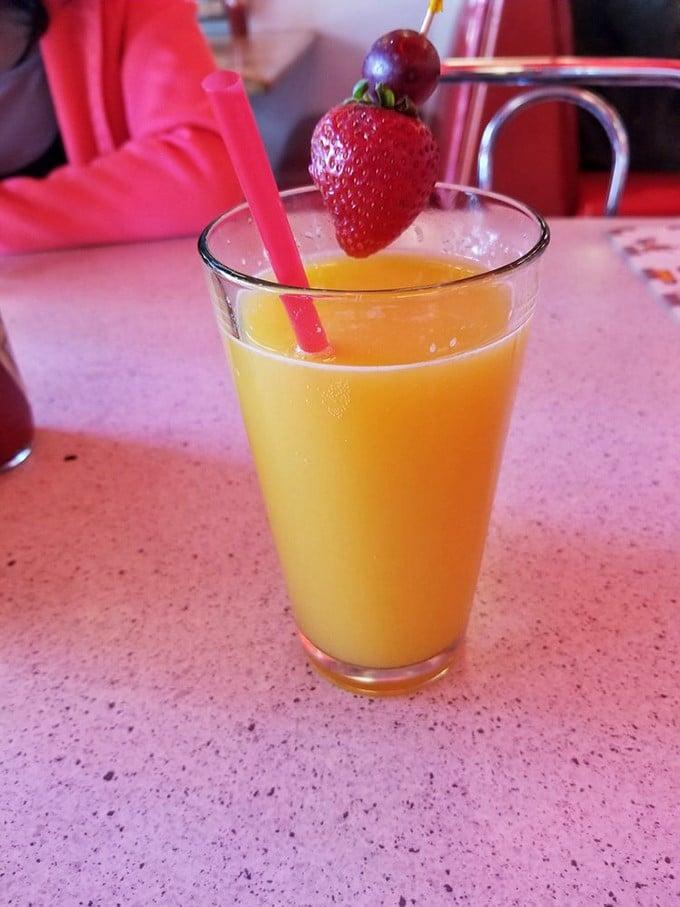 Sunshine in a glass with a strawberry on top – the kind of fresh-squeezed happiness that makes mornings bearable.