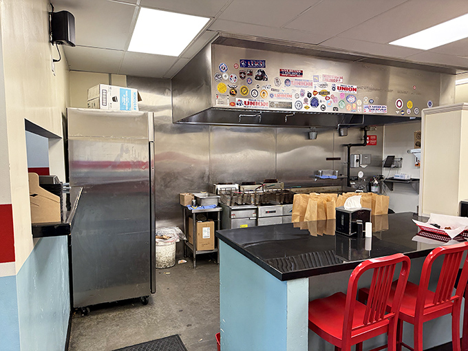 A glimpse into the kitchen reveals the sticker-adorned heart of the operation, where burger magic happens without smoke and mirrors—just fire and skill. 