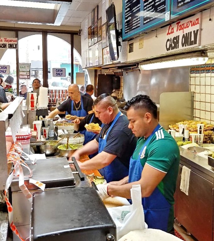 Open kitchen choreography reveals skilled cooks crafting each order with practiced precision and pride.