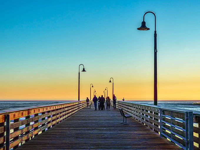 Sunset strolls on Cayucos Pier—where strangers become temporary friends united by nature's nightly masterpiece over the Pacific.