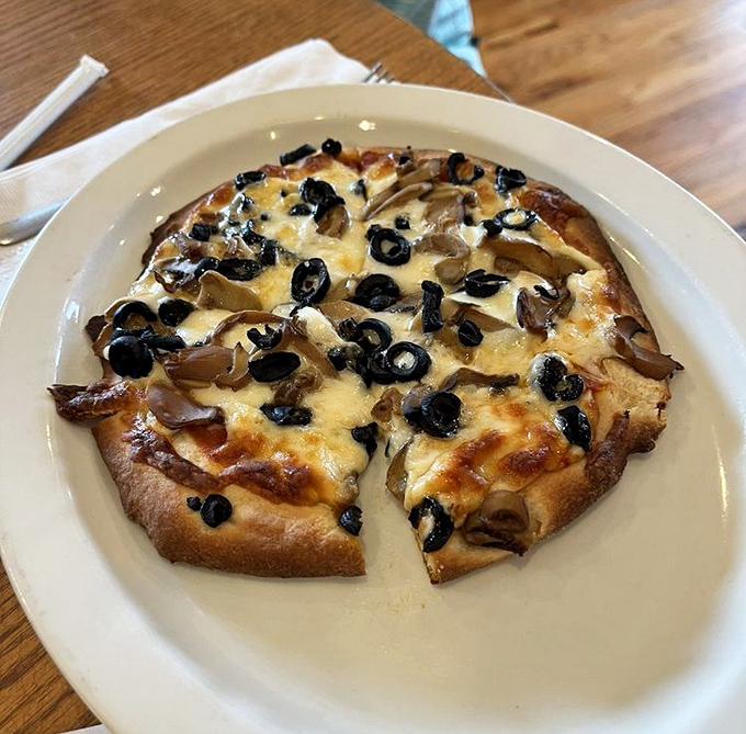 Pizza with a crust that's earned its reputation over decades. Those black olives and mushrooms aren't just toppings—they're a commitment to flavor.