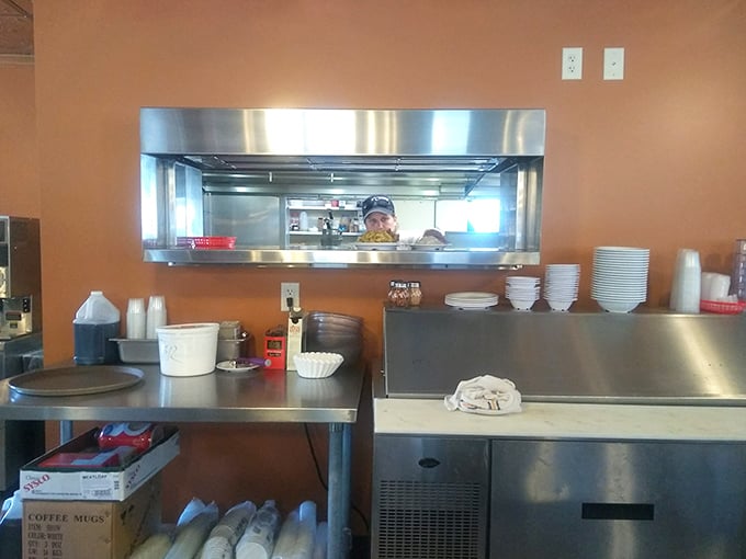 Where the magic happens—a kitchen window offering glimpses of culinary choreography that's been perfected over decades, not culinary school.