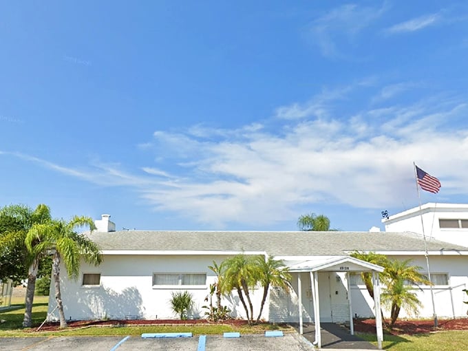 This modest white building with palm trees and an American flag represents Florida retirement living without the South Beach price tag.