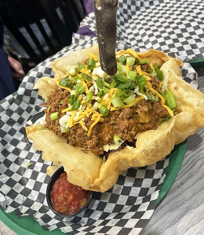 A taco salad that's actually a crispy edible bowl holding a fiesta. The fork standing tall says, "Challenge accepted."