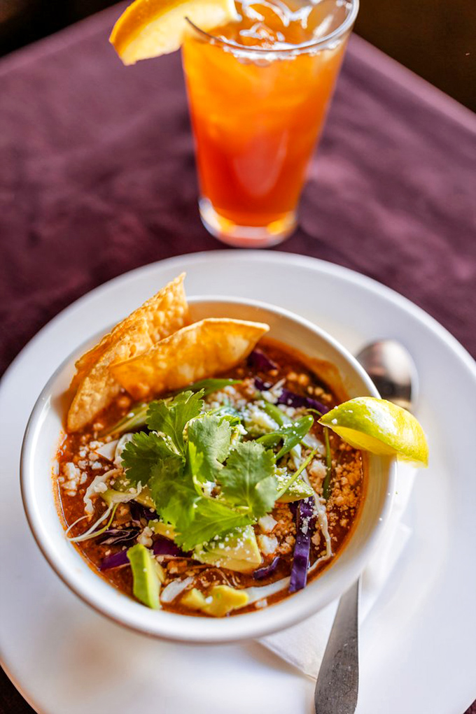 This tortilla soup is like a warm hug in a bowl, where cilantro, cheese, and crispy tortilla strips throw a fiesta for your taste buds.