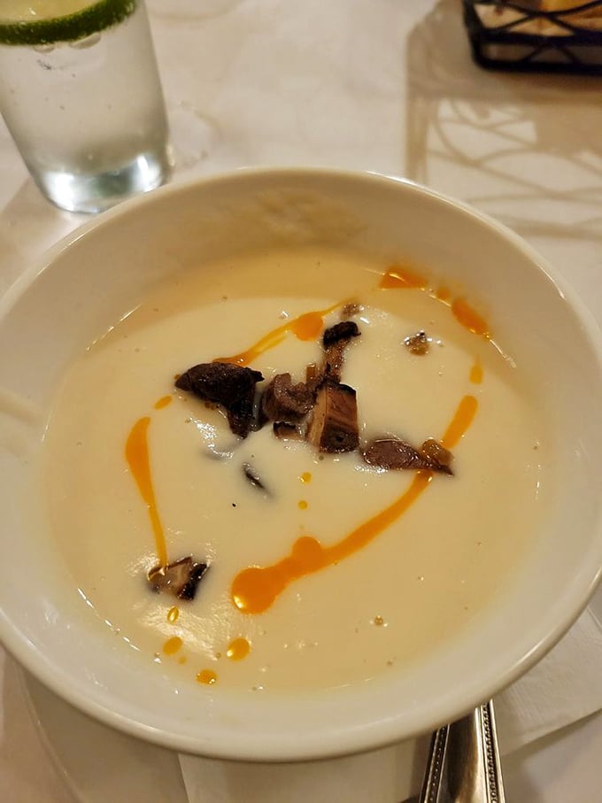 This isn't just soup—it's a silky canvas of turnip velouté with mushroom islands and a sunset drizzle of what must be chili oil.