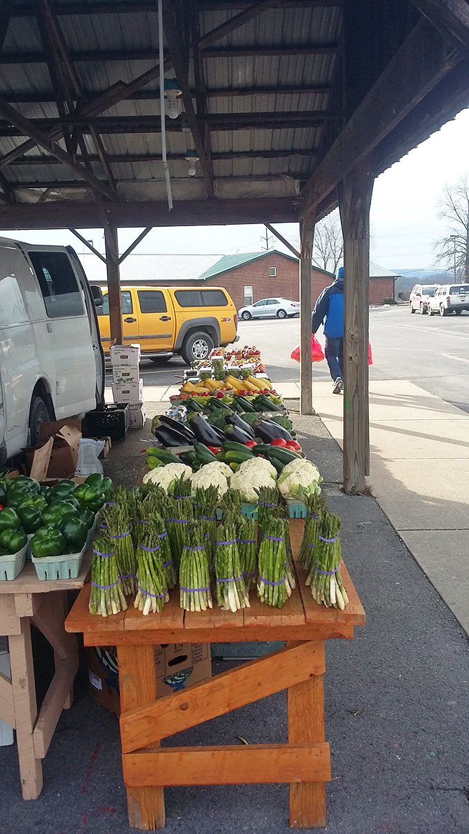 Spring's bounty on display! Fresh asparagus, cauliflower, and eggplant create a rainbow of nutrition under the market's rustic covered walkway.
